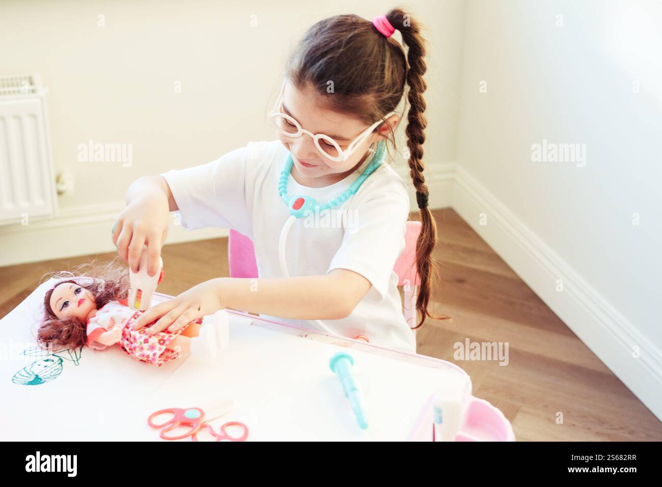 Adorable toddler girl in white coat with syringe playing doctor and ...