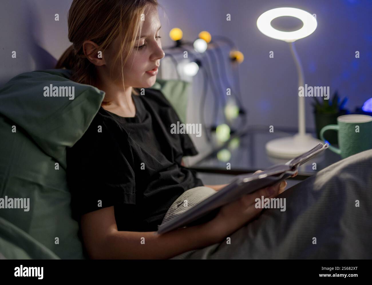 Cute Little Girl In Bed Reading A Book Aloud Before Sleep Stock Photo ...