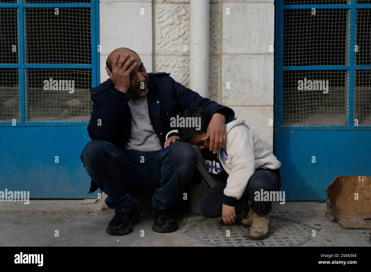 Mourners wait outside the morgue for the funeral of six Palestinians ...