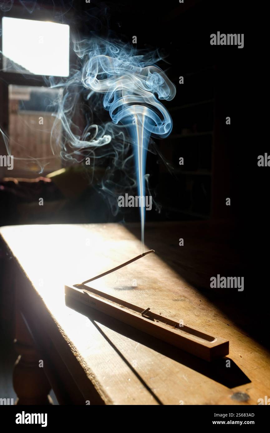 Interesting smoke patterns from a lit incense stick on a dining room ...