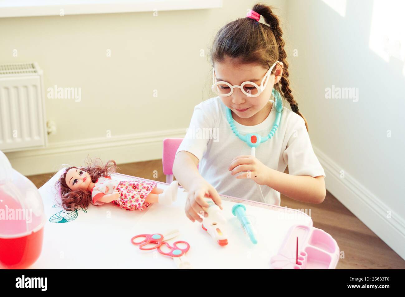 Adorable toddler girl in white coat with syringe playing doctor and ...