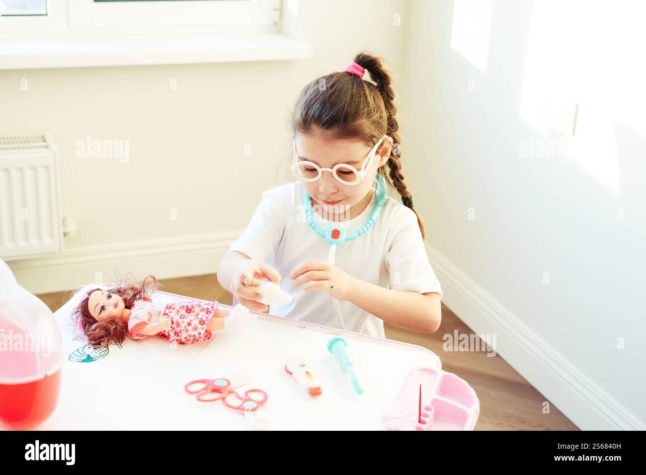 Adorable toddler girl in white coat with syringe playing doctor and ...