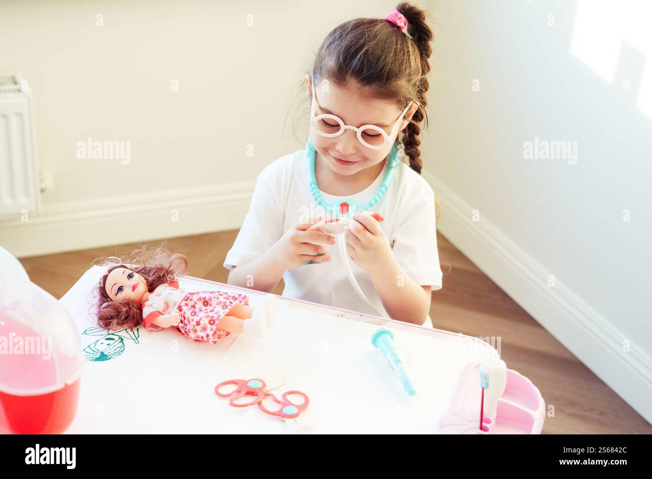 Adorable toddler girl in white coat with syringe playing doctor and ...