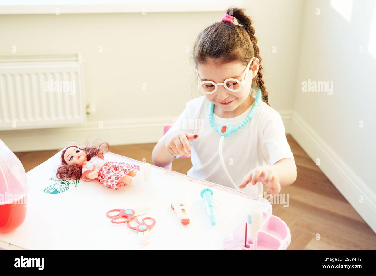 Adorable toddler girl in white coat with syringe playing doctor and ...