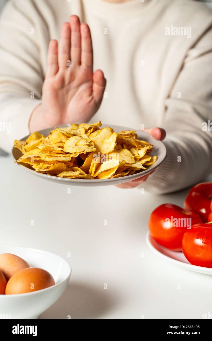 Vertical Closeup of woman making stop sign to refuse fried chips for ...