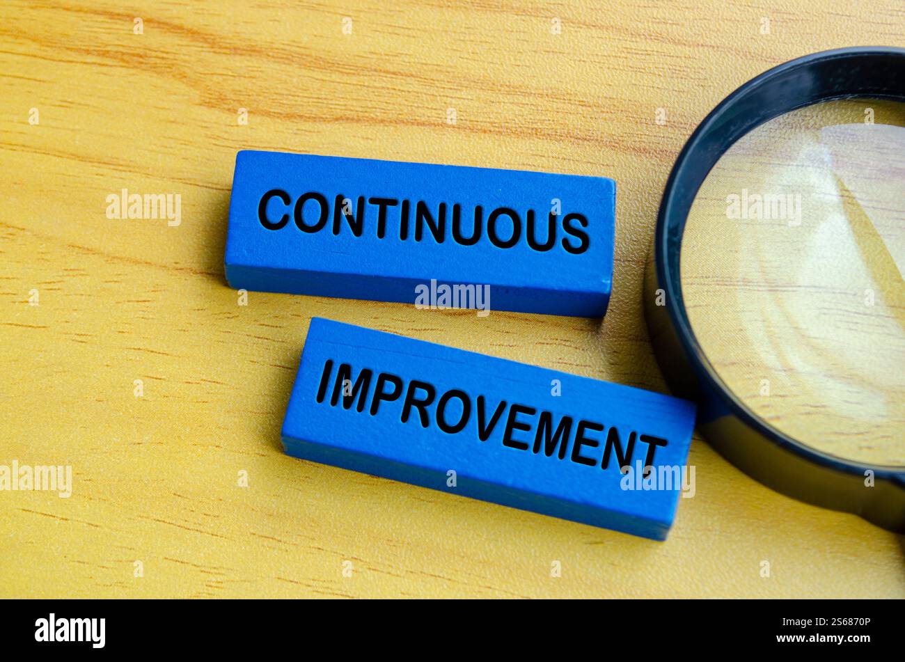 Top view of continuous improvement text on blue wooden blocks with ...