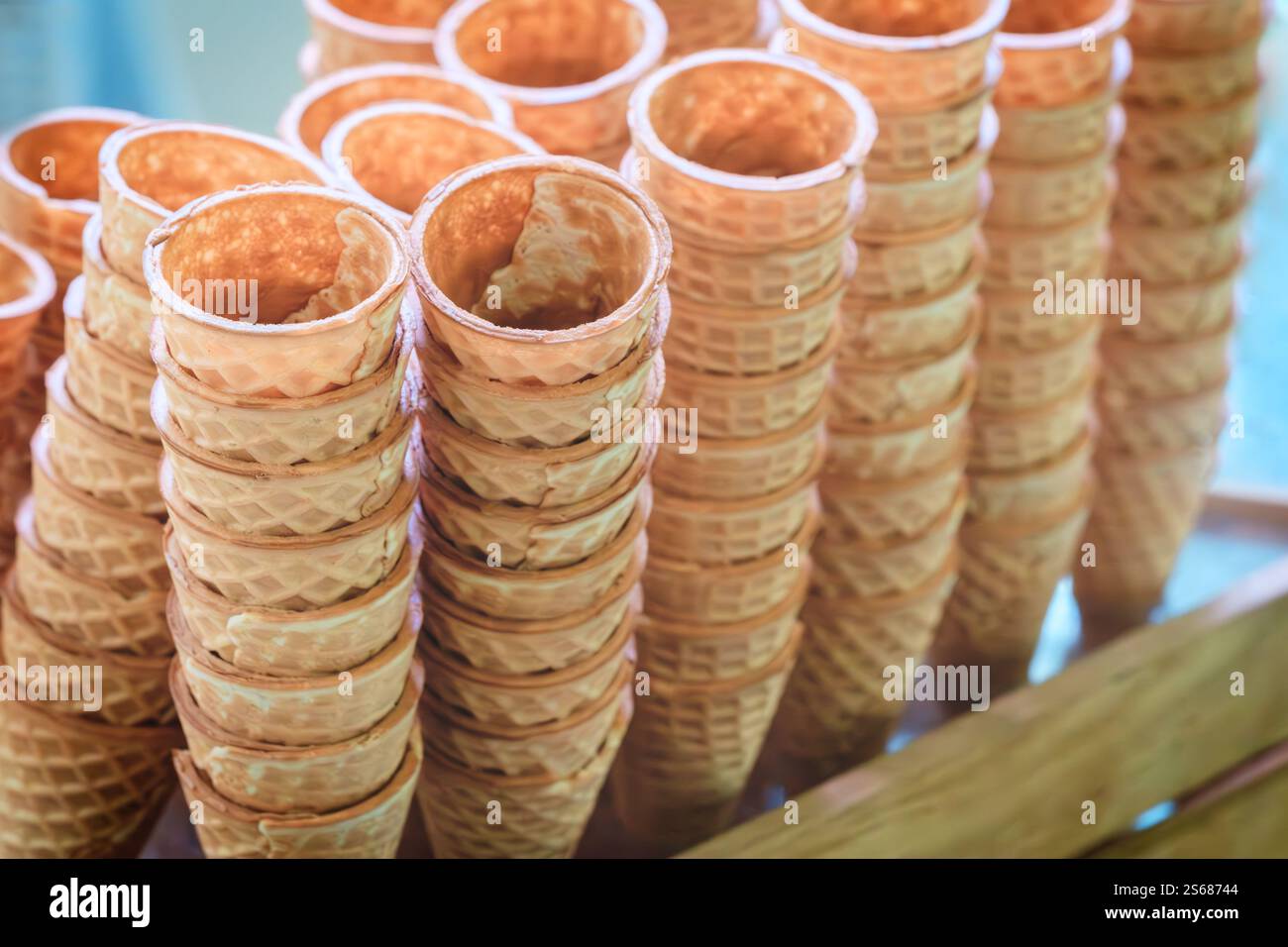 A stack of ice cream cones with a wooden box underneath. The cones are ...