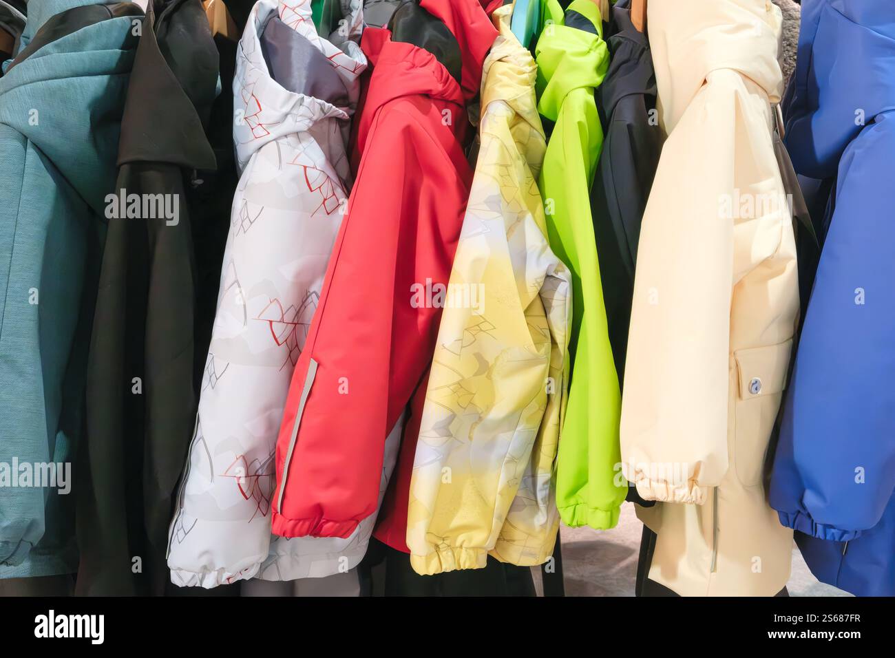 A row of colorful jackets hanging on a rack. The jackets are of ...