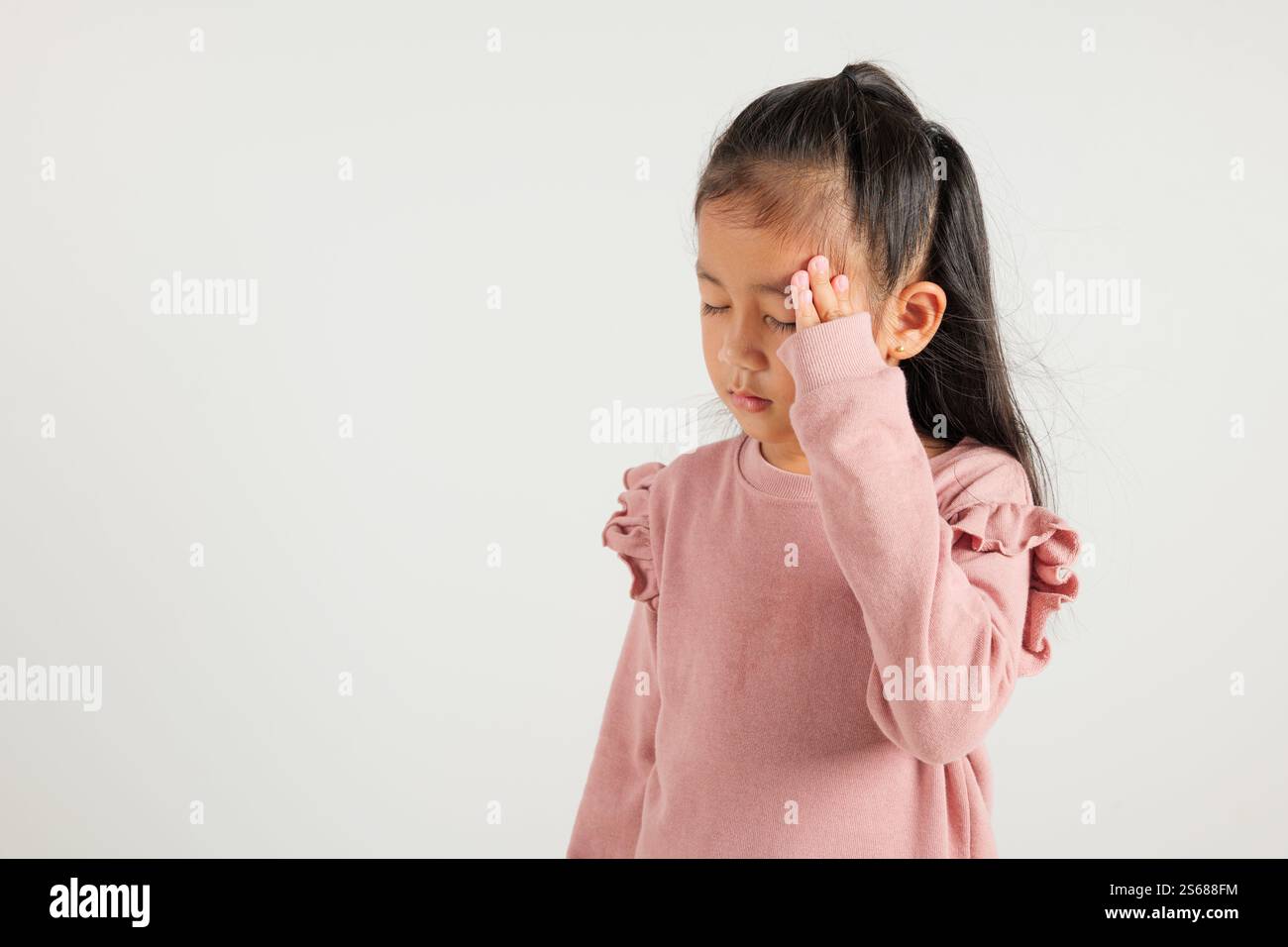 Portrait of Asian young kid girl sad tired strain face holding hold ...