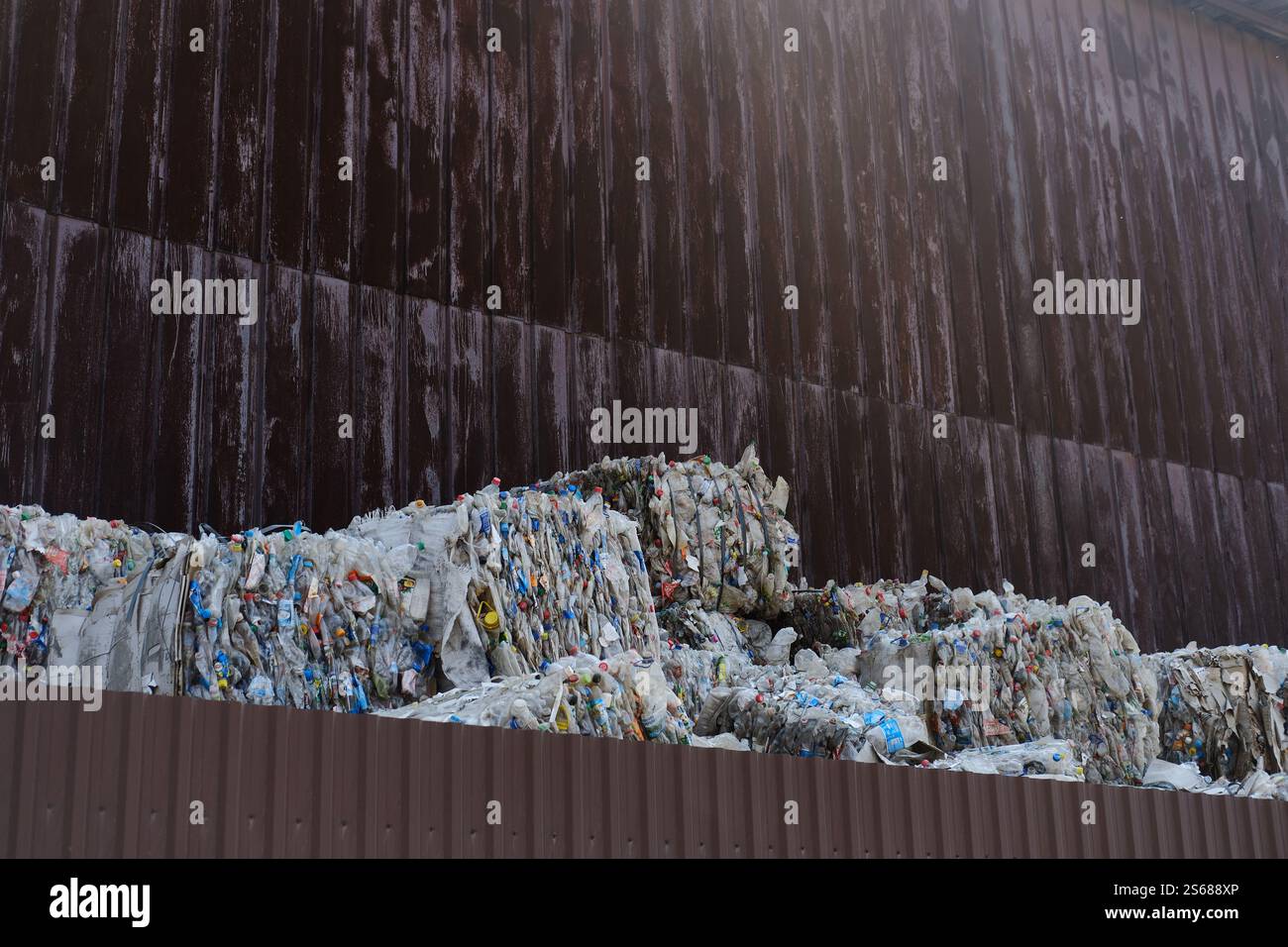 Plastic bottles compressed into cubes and ready for recycling against ...