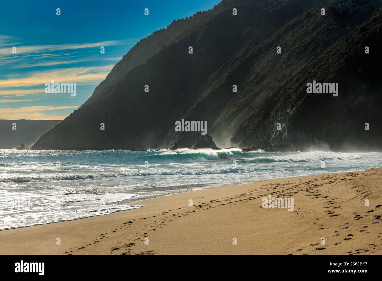 Waves crashing on the sandy shore of Quintay Beach in Chile during a ...