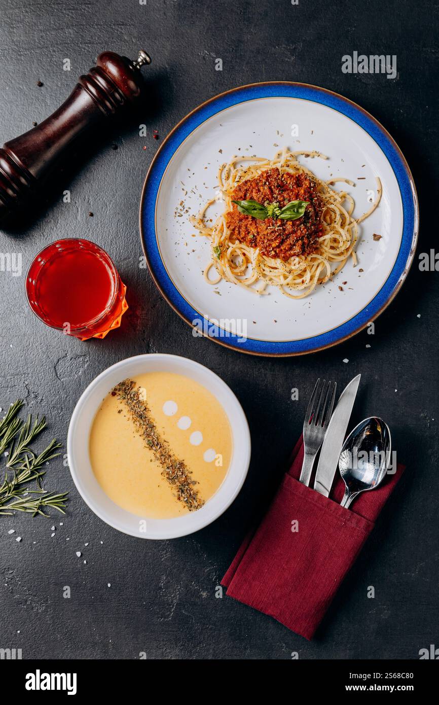 Business lunch with spaghetti bolognese and creamy soup, garnished with ...