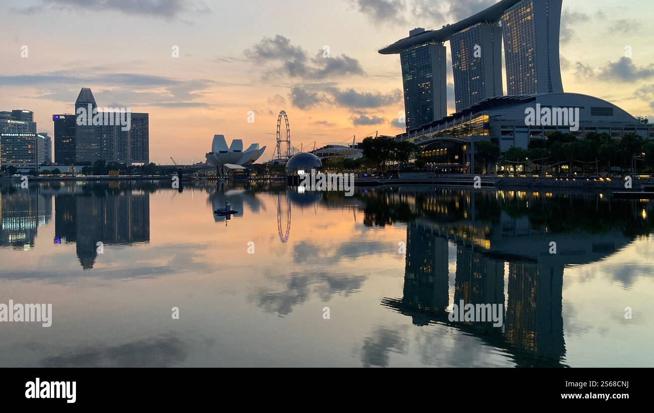 The iconic Marina Bay Sands building reflecting in the water at dawn ...