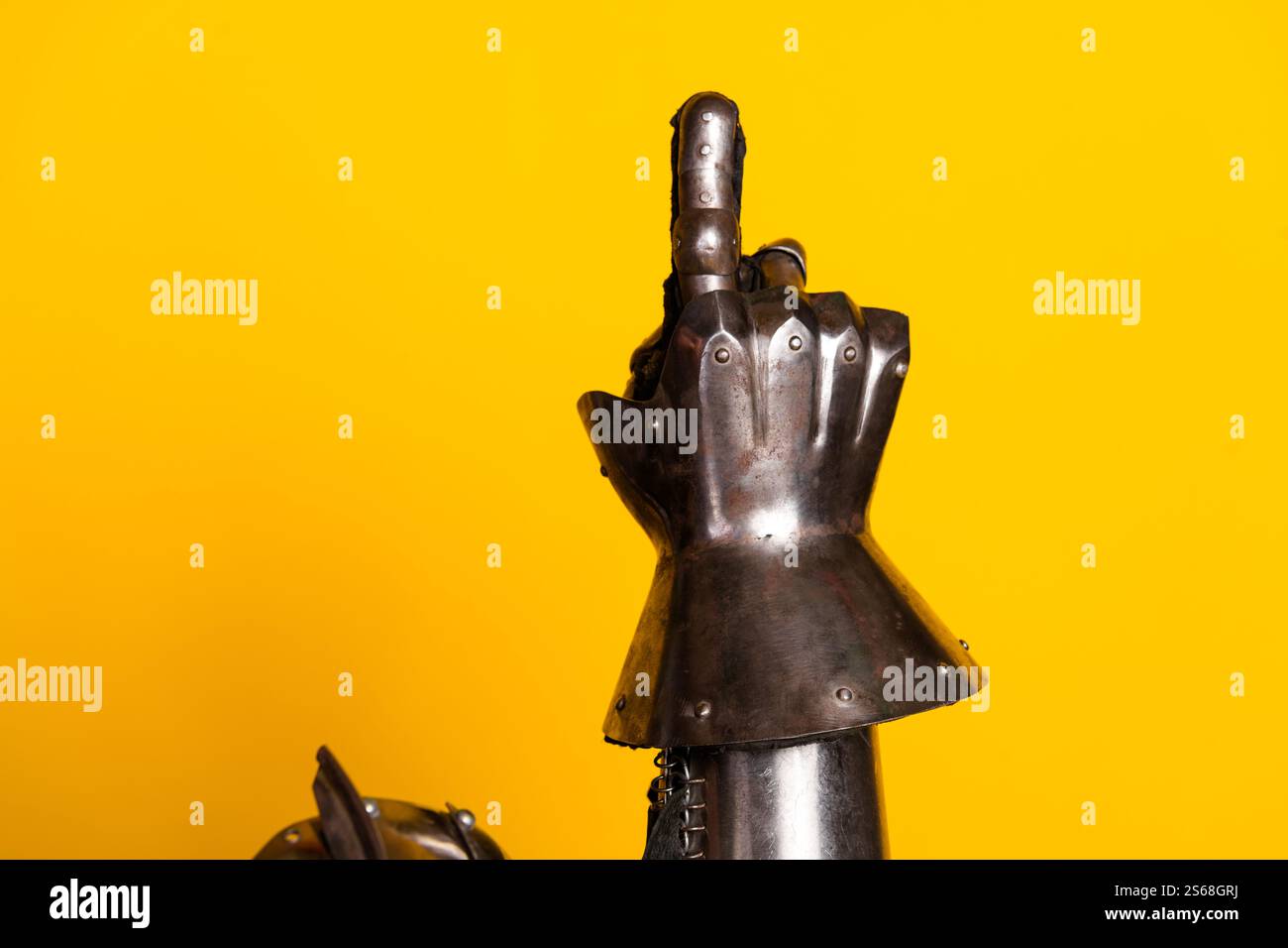 A knight's armored hand gesturing on a vibrant yellow background ...