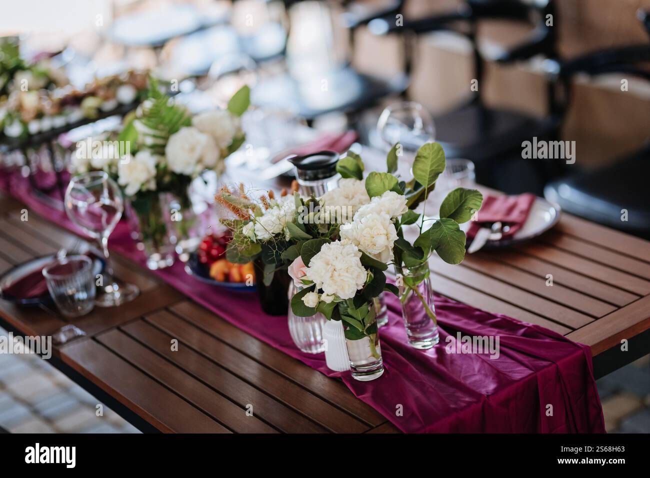 Luxurious dining table setup with flowers, appetizers, and wine glasses for an elegant ...