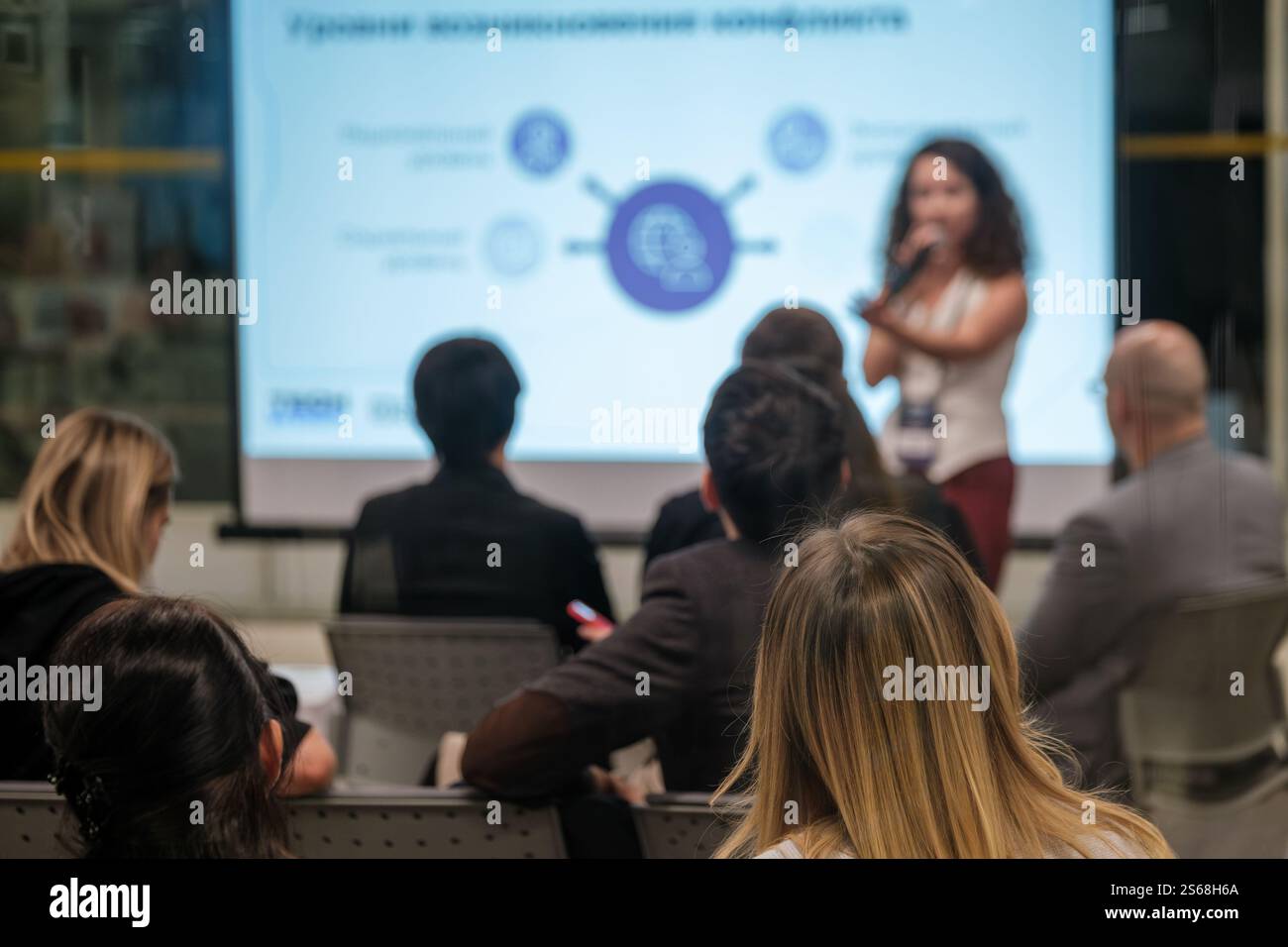 Group of professionals attentively watching speaker in a business ...