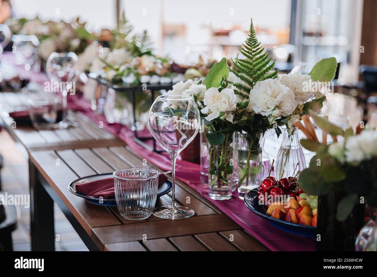 Luxurious dining table setup with flowers, appetizers, and wine glasses for an elegant ...
