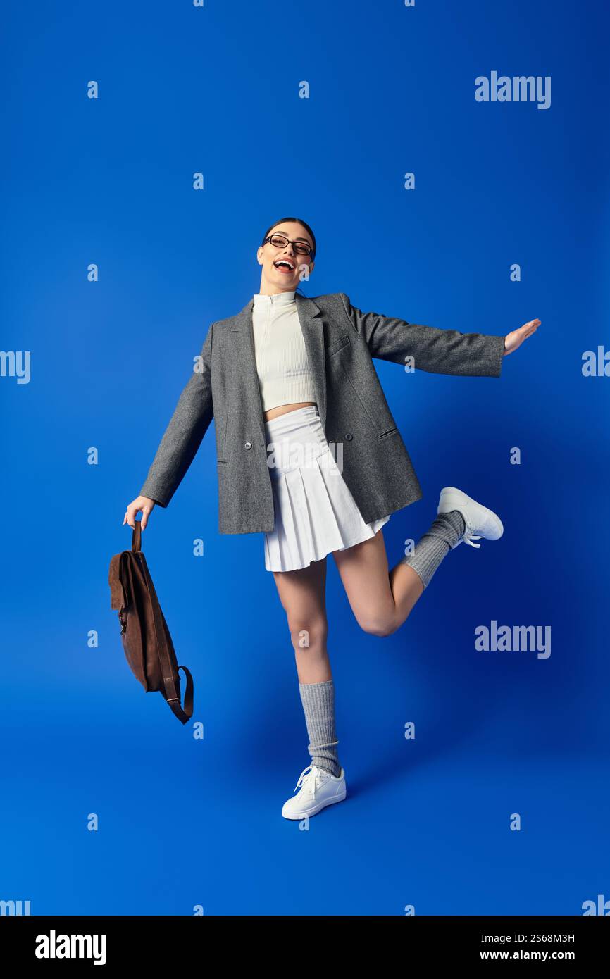 A young woman radiates joy while posing in a fashionable outfit ...