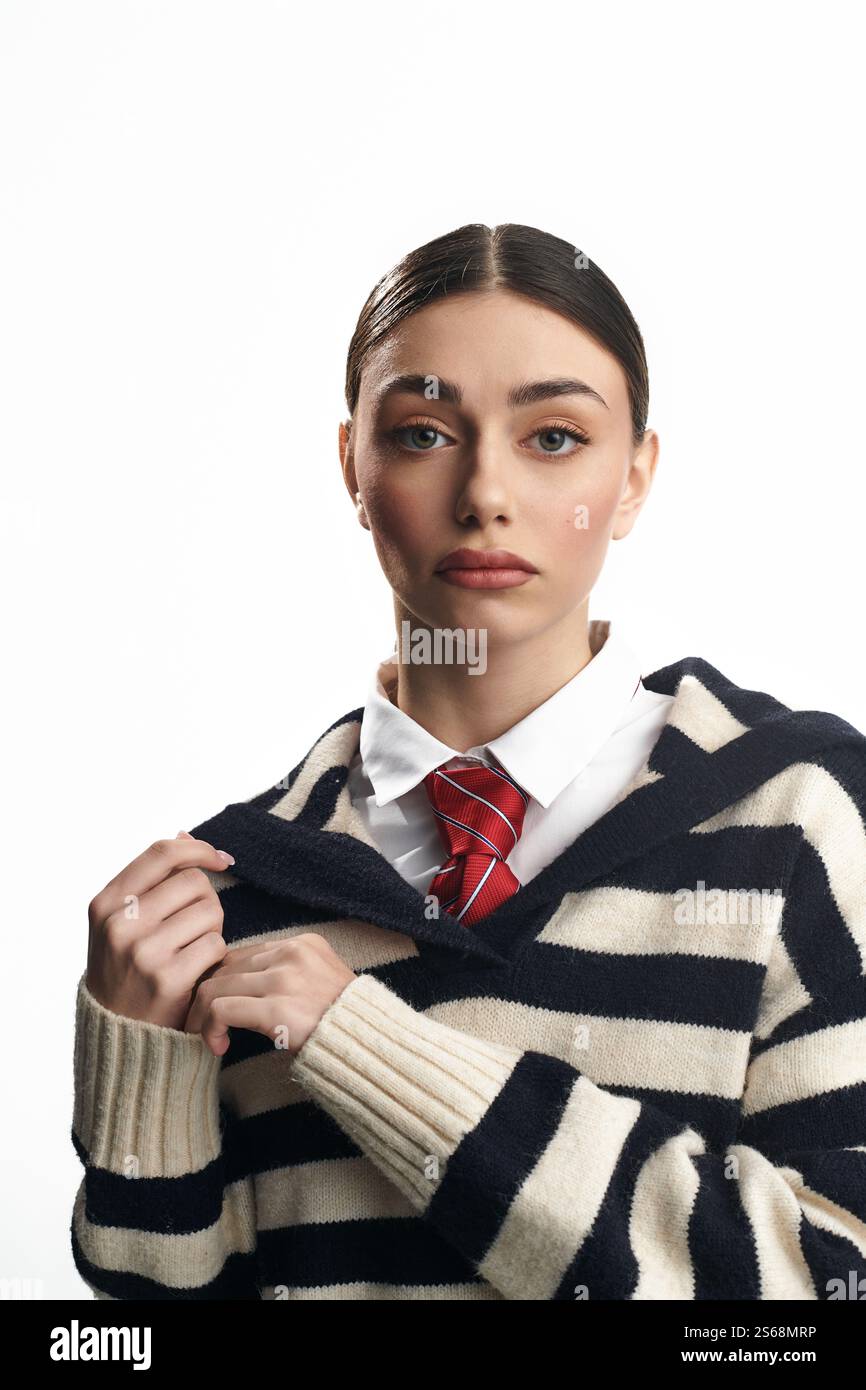 Young woman wearing a striped sweater and tie reveals her emotions ...
