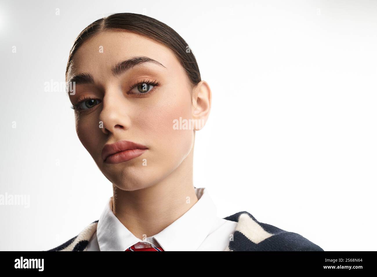 A young woman draws attention with her striking expression and stylish ...