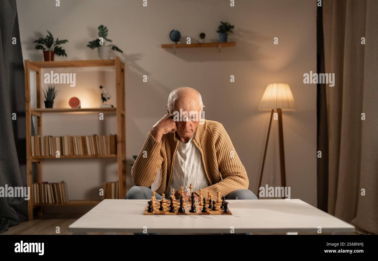 Elderly gentleman enjoys thoughtful chess game, using hobby to improve ...