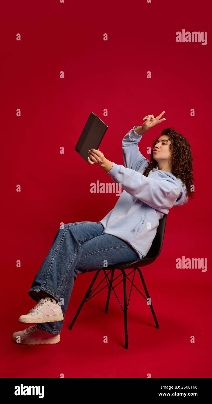 Body-size photo of woman, blogger sitting on chair, taking selfie on ...