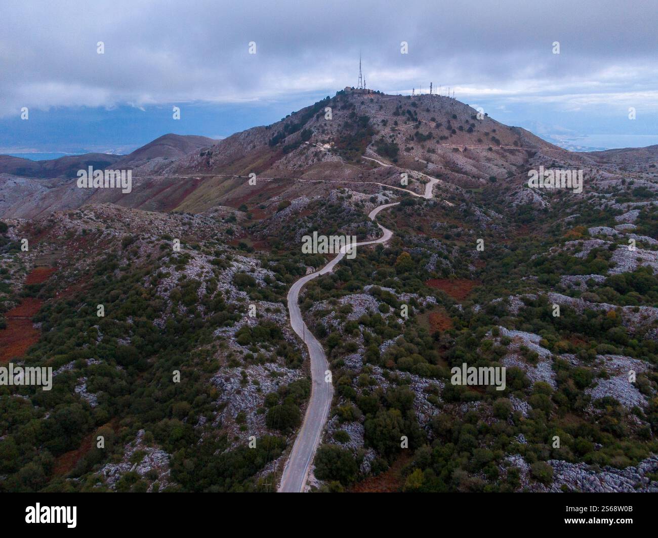 Winding mountain road leading to a summit with communication towers ...