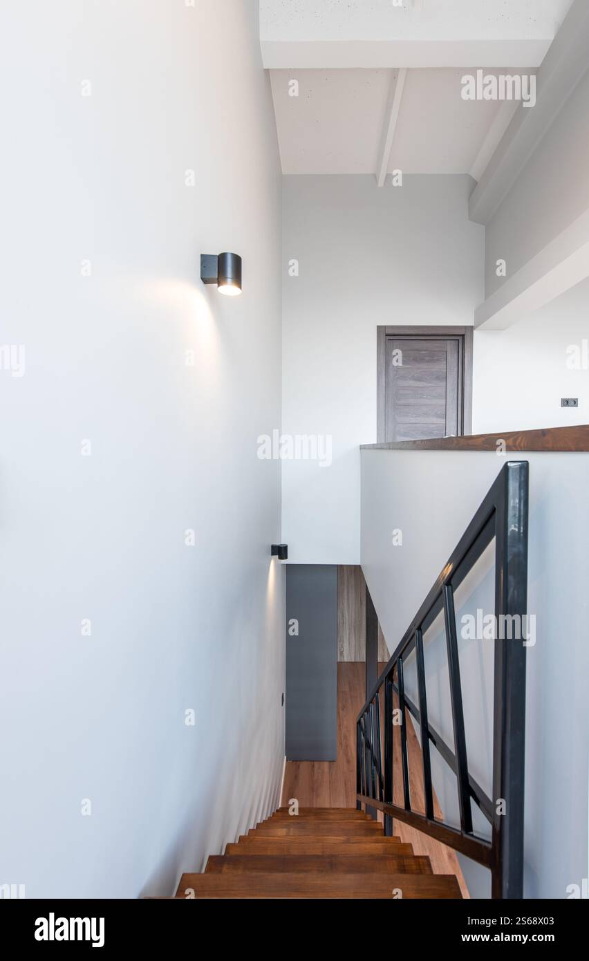 Sleek modern staircase interior featuring wooden steps, metal railings ...