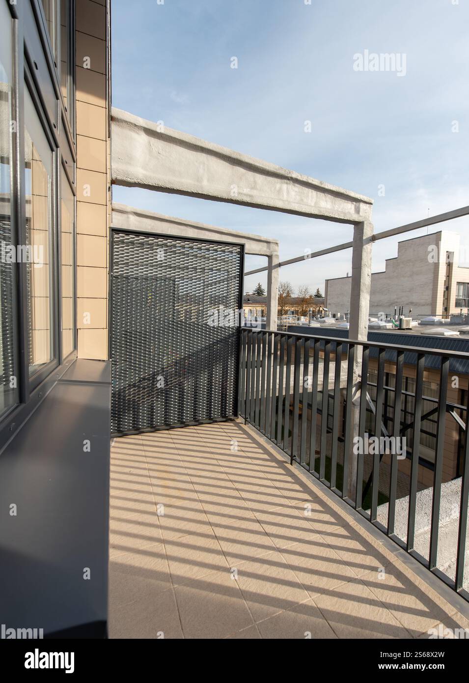 A contemporary balcony with railings, overlooking urban rooftops and ...