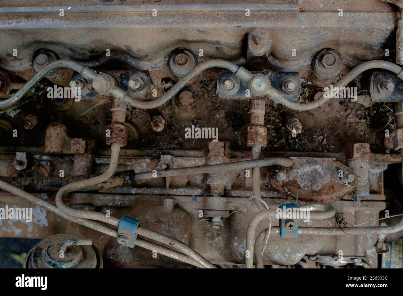A detailed image of an aged, rusty engine block showcasing fuel lines ...