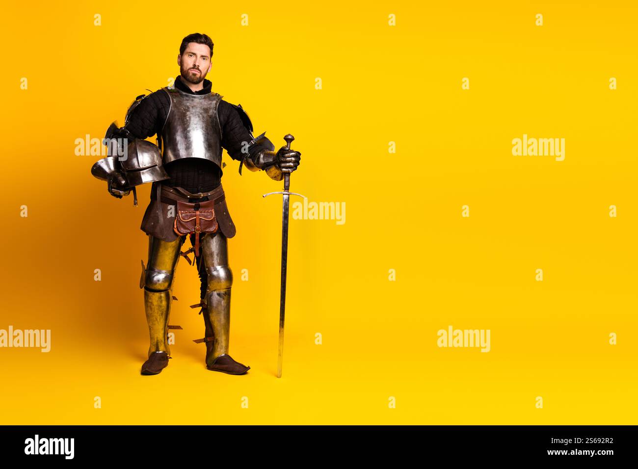 Portrait of a knight in full medieval armor on a vibrant yellow ...