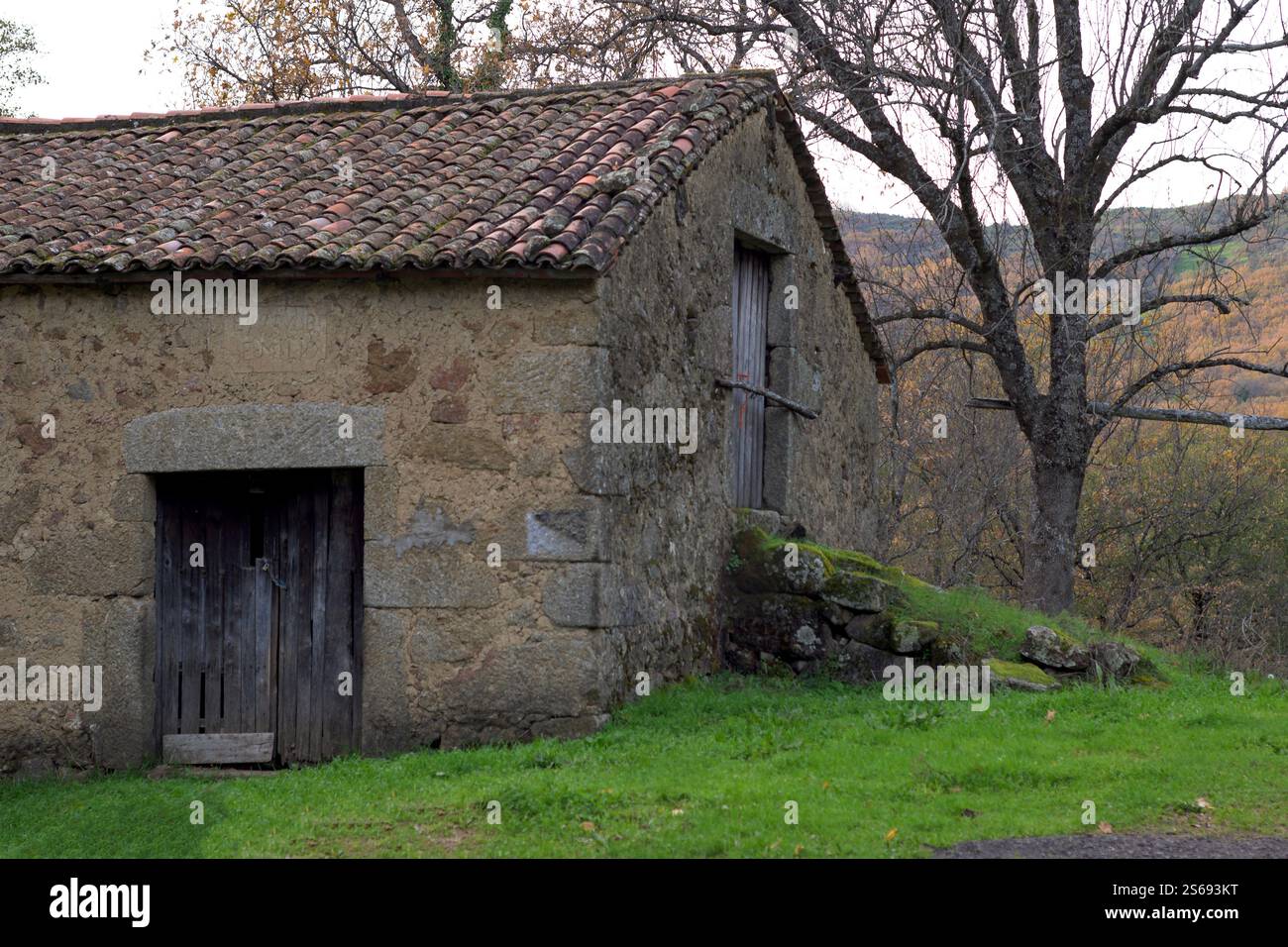 Old stone house in rural countryside area with old wooden doors and ...