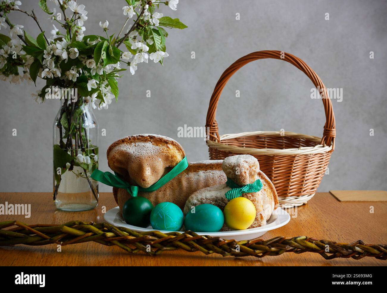 Easter still life containing two lamb cakes, four painted eggs, a ...