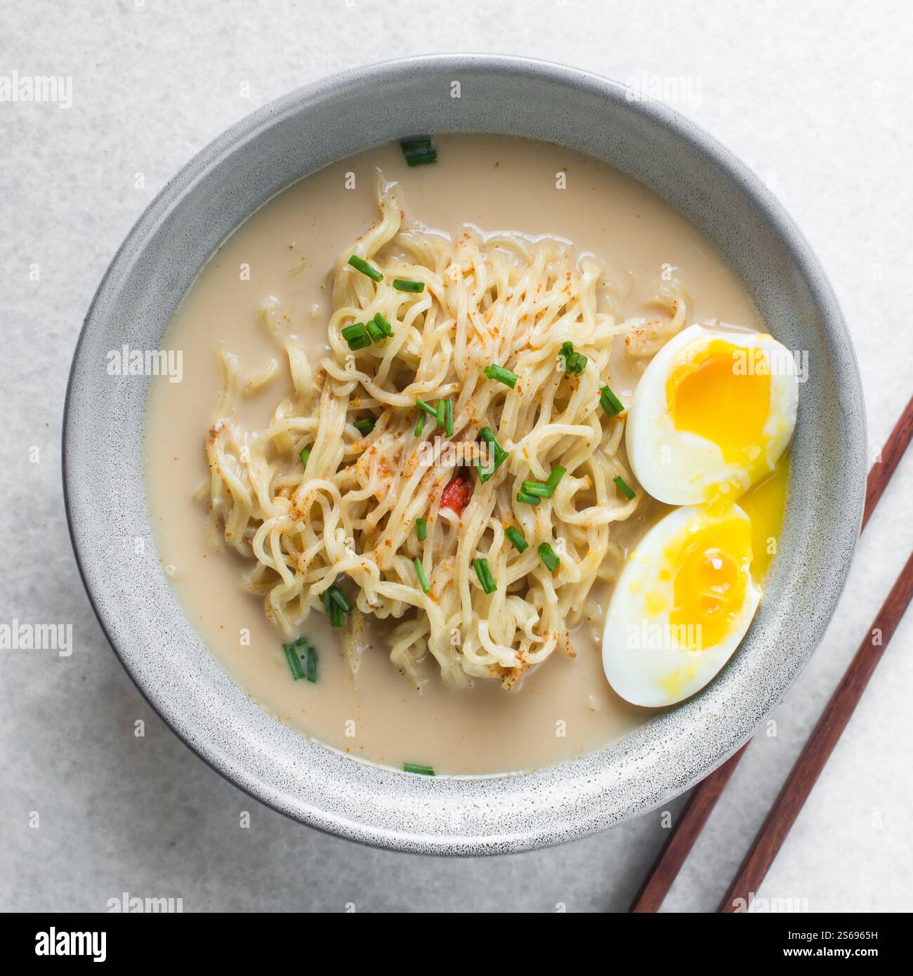 Overhead view of noodles in milk broth in a grey bowl, top view of ...