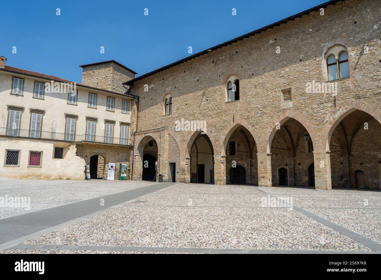 A historic stone building featuring large arched porticoes and ...