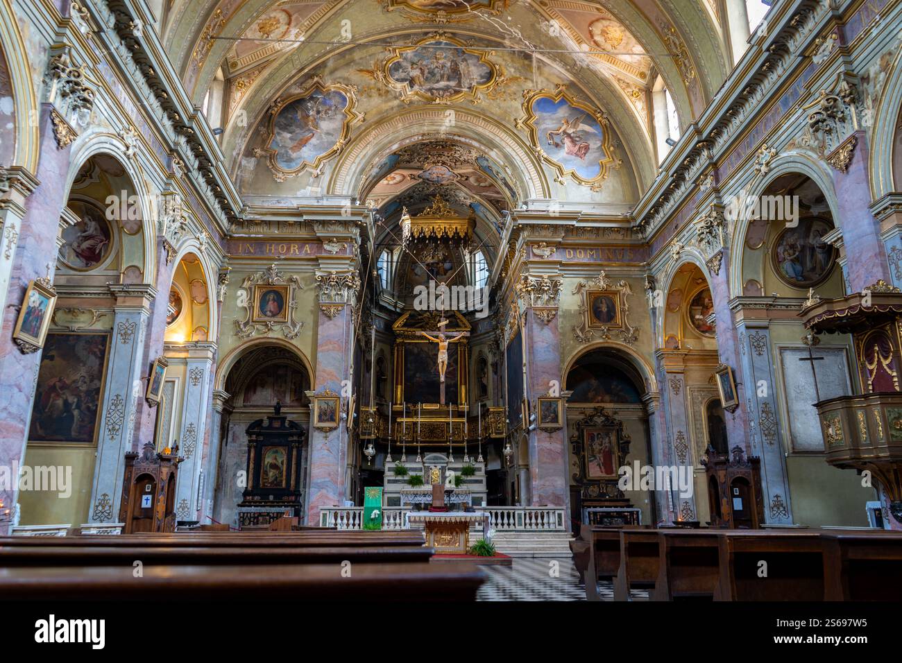 A richly decorated church interior featuring frescoed ceilings, intricate arches, a crucifix ...