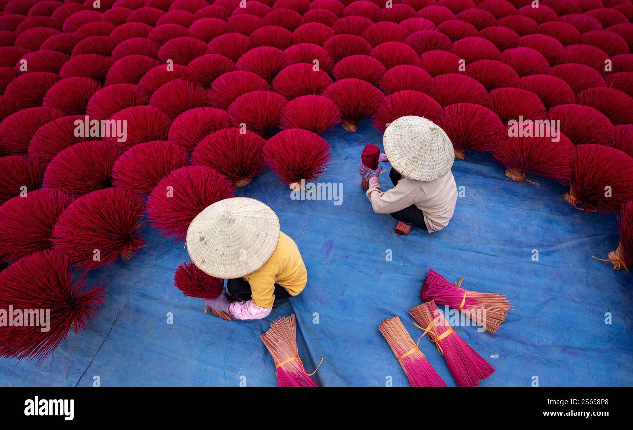 Aerial view of incense workers sits surrounded by thousands of incense ...