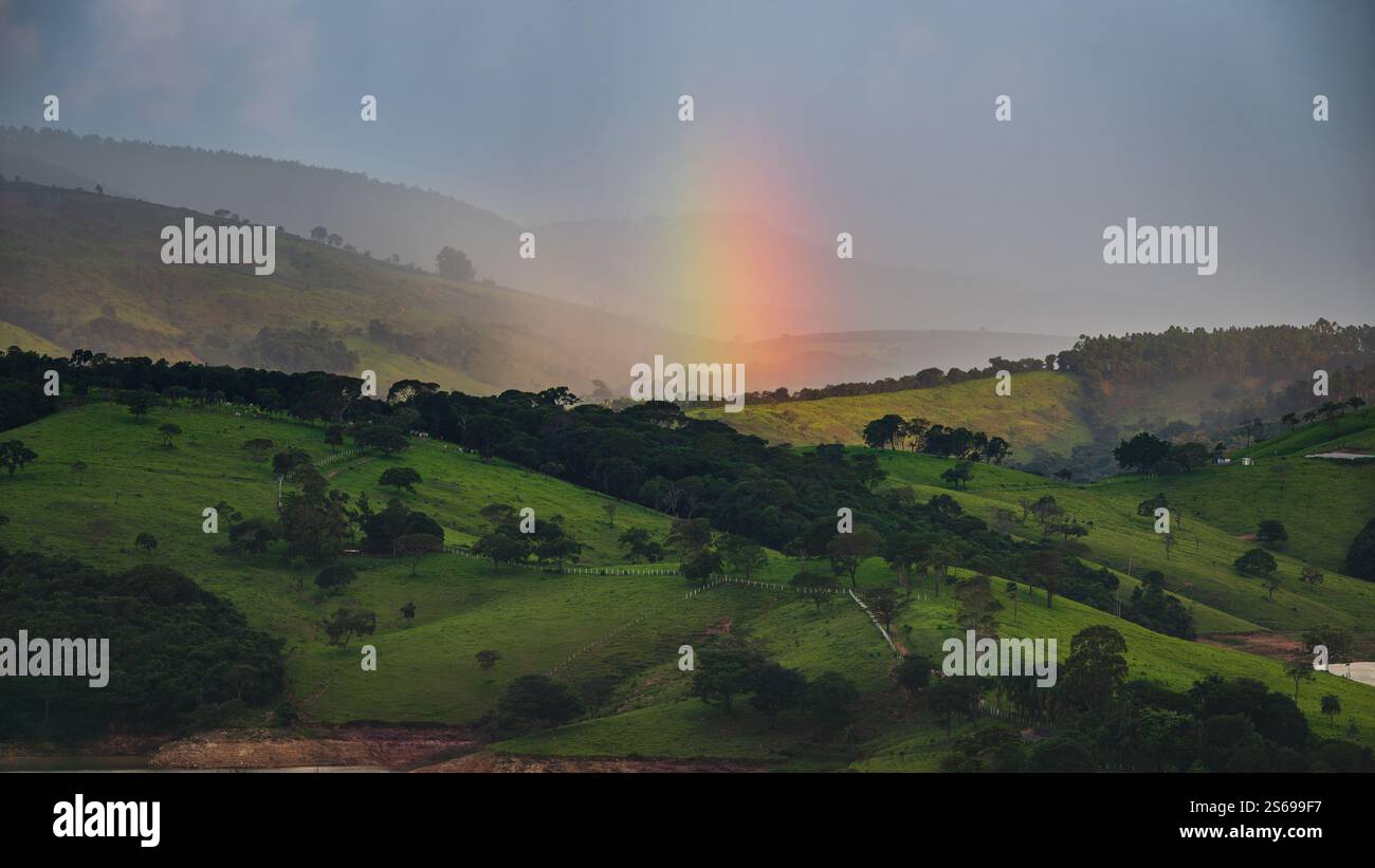Horizontal view of landscape with rainbow over farmland in Capitólio ...