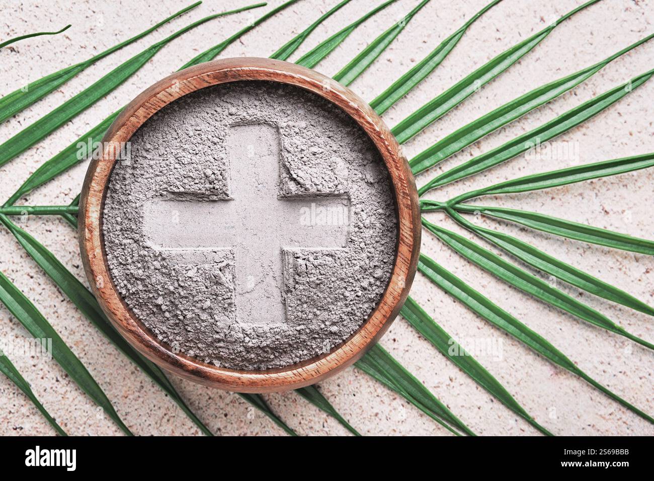 Cross in ashes on a palm leaf background - symbols of Ash Wednesday ...