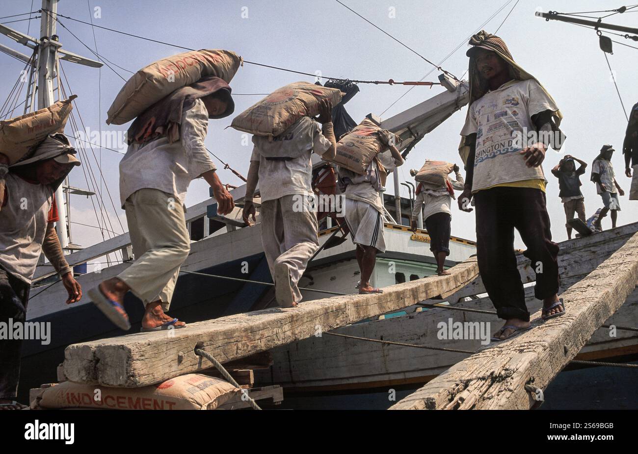 09.08.2009, Jakarta, Indonesia, Asia - Dock workers load goods onto a cargo sailing ship (Pinisi ...