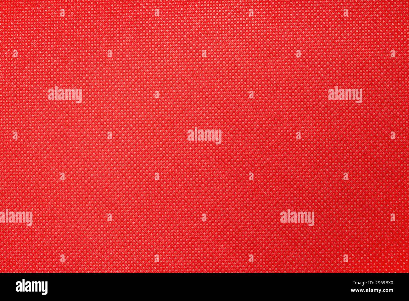 a close-up of a red fabric featuring a fine textured pattern ...