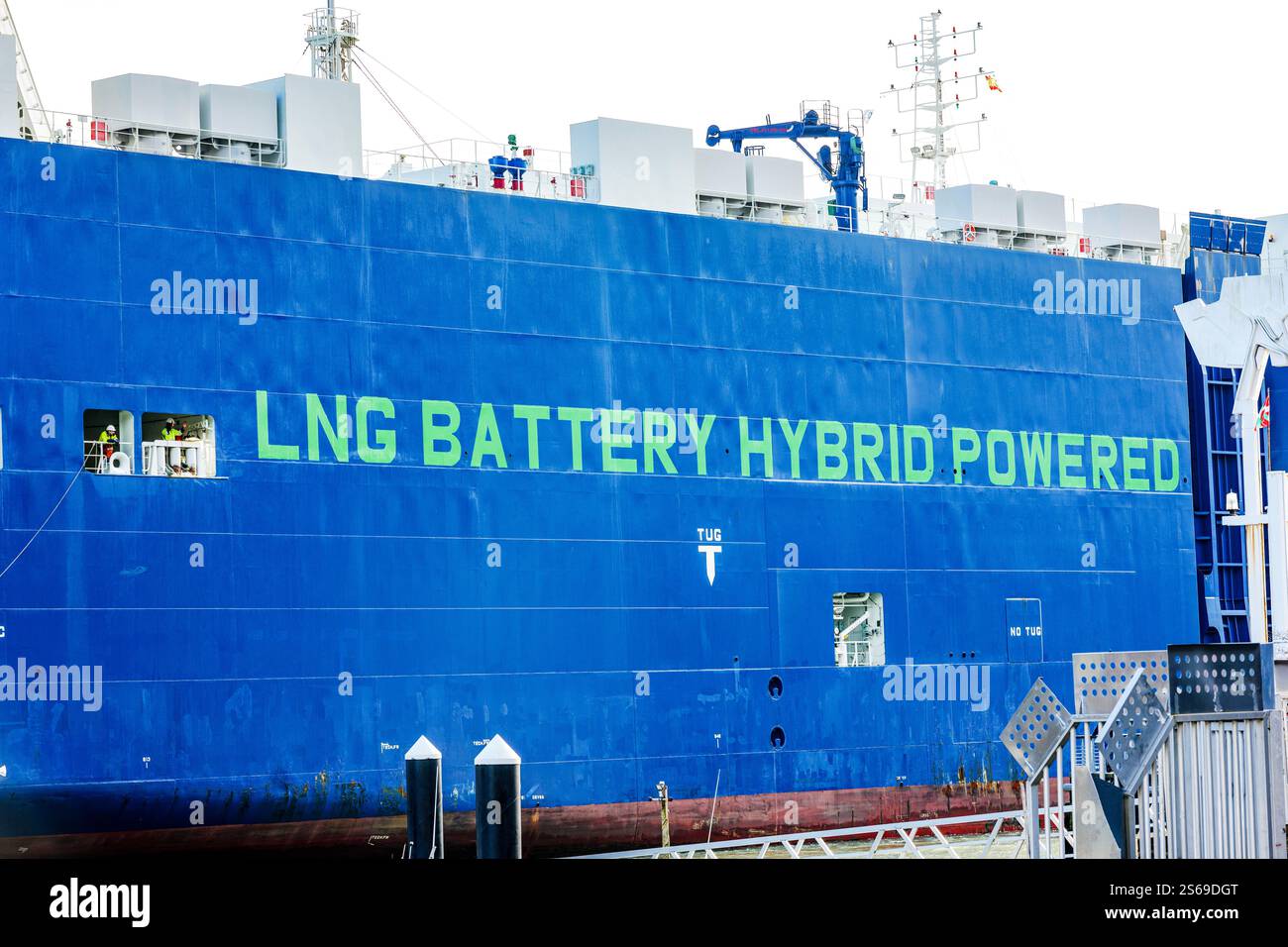A large hybrid-powered cargo ship docked in a harbor Stock Photo - Alamy