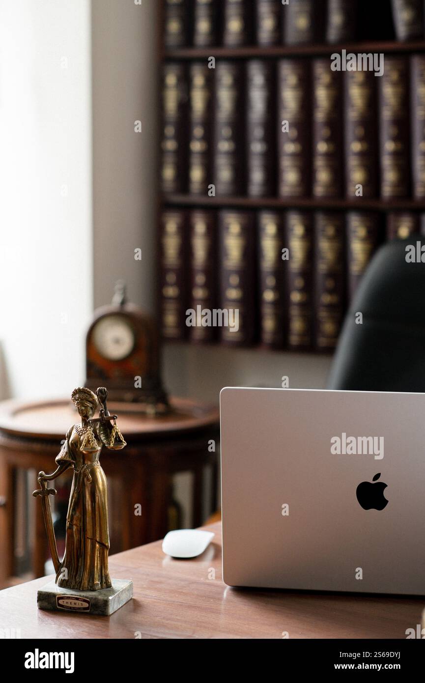 A lawyer’s office with bookshelves, antique clocks, and a Lady Justice ...