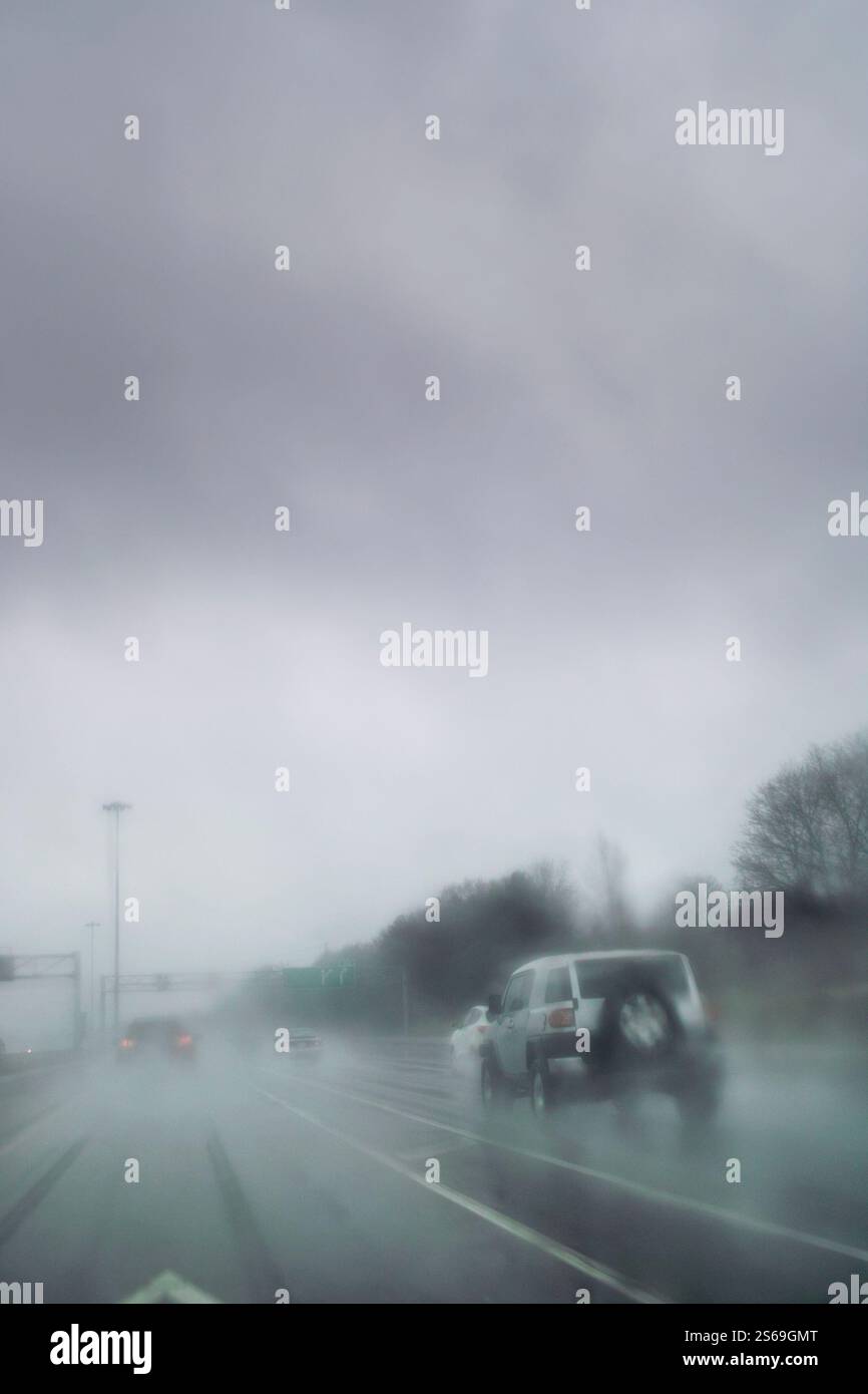 Cars driving in bad weather conditions with fog and heavy rain on ...