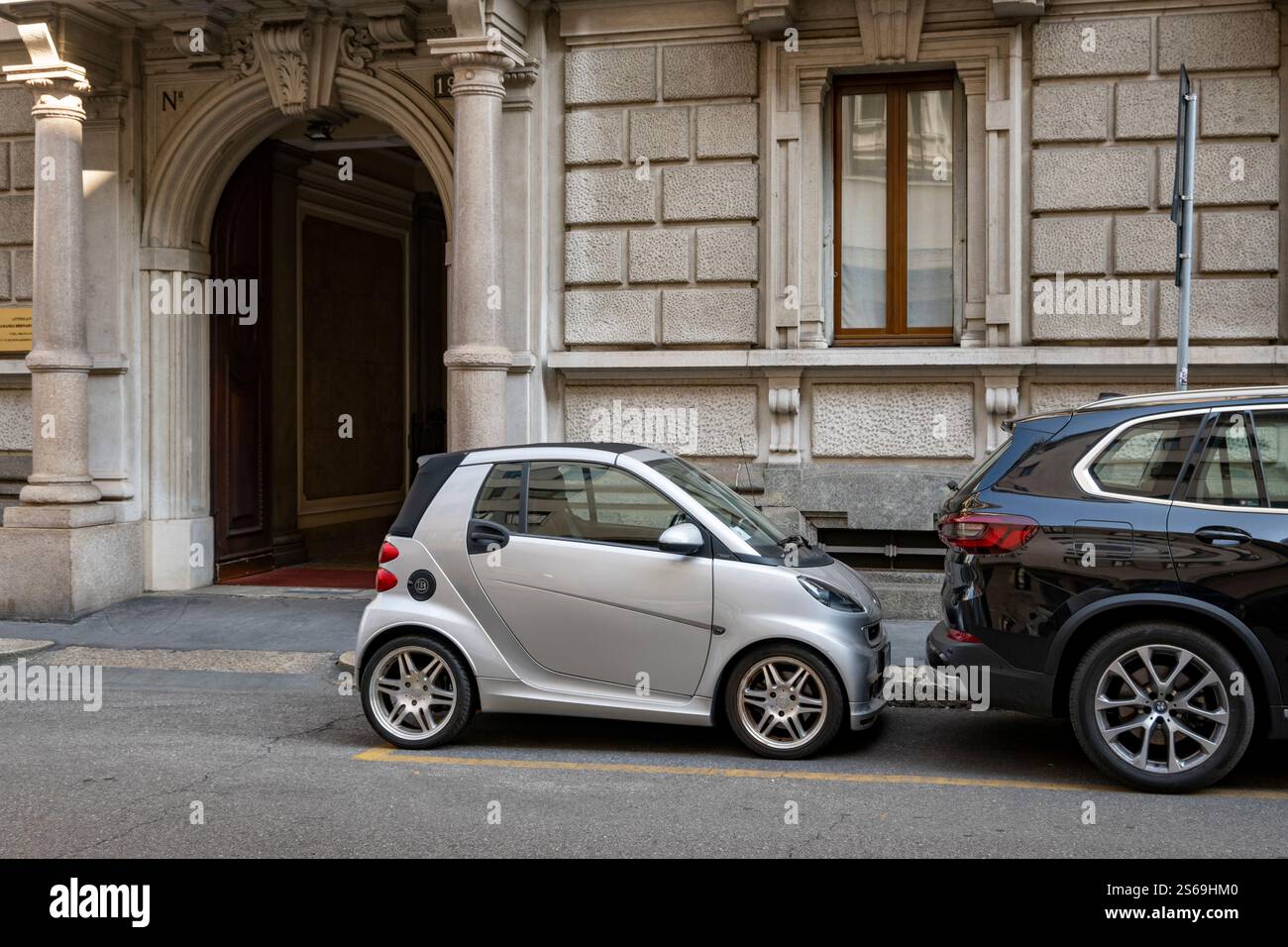 Comparison between a smart car and larger car parking Stock Photo - Alamy