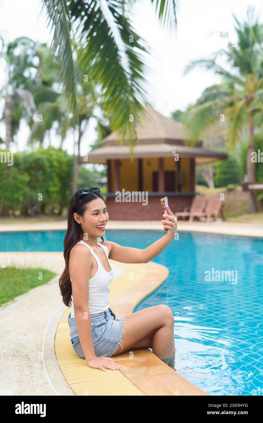 Asian woman taking selfie in swimming pool Stock Photo - Alamy