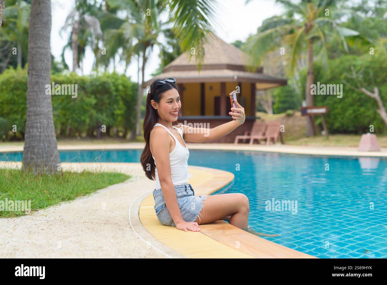 Asian woman taking selfie in swimming pool Stock Photo - Alamy