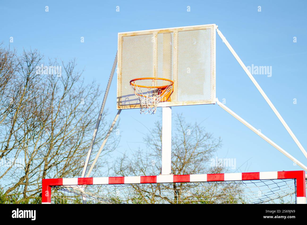a basketball basket made of a rusty white metal backboard installed on ...