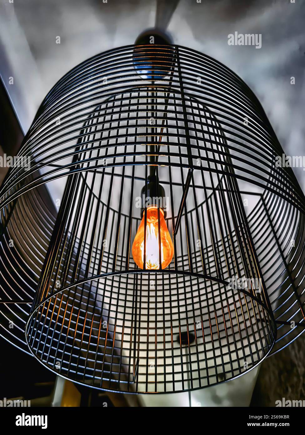 An electric light bulb in a mesh light shade Stock Photo - Alamy