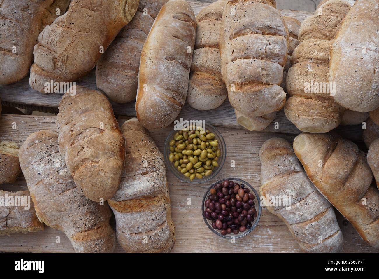 Traditional handmade Cretan loaves of bread with green and black olives ...